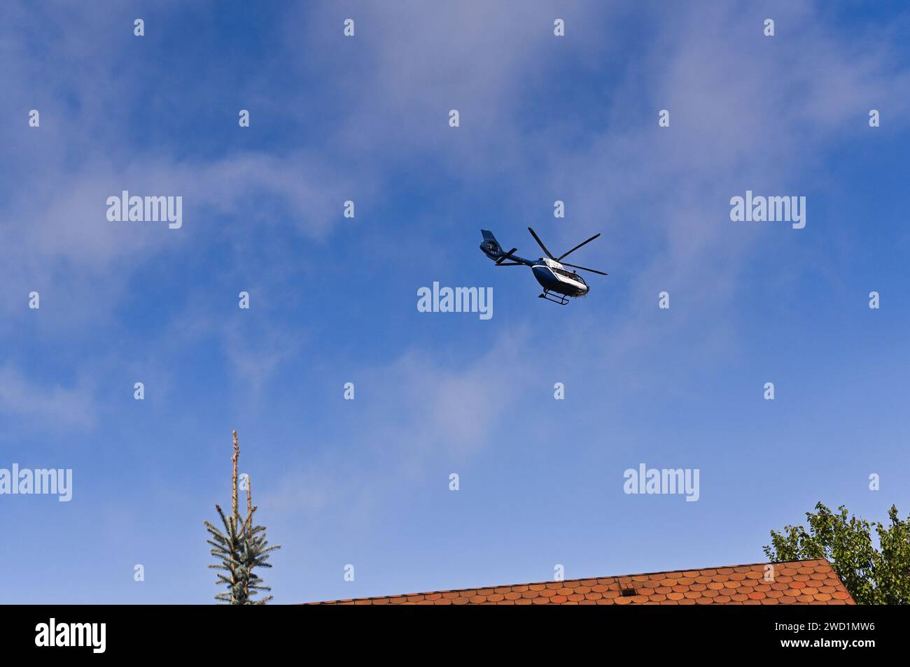 A helicopter is flying in the sky above the roof of the house Stock ...