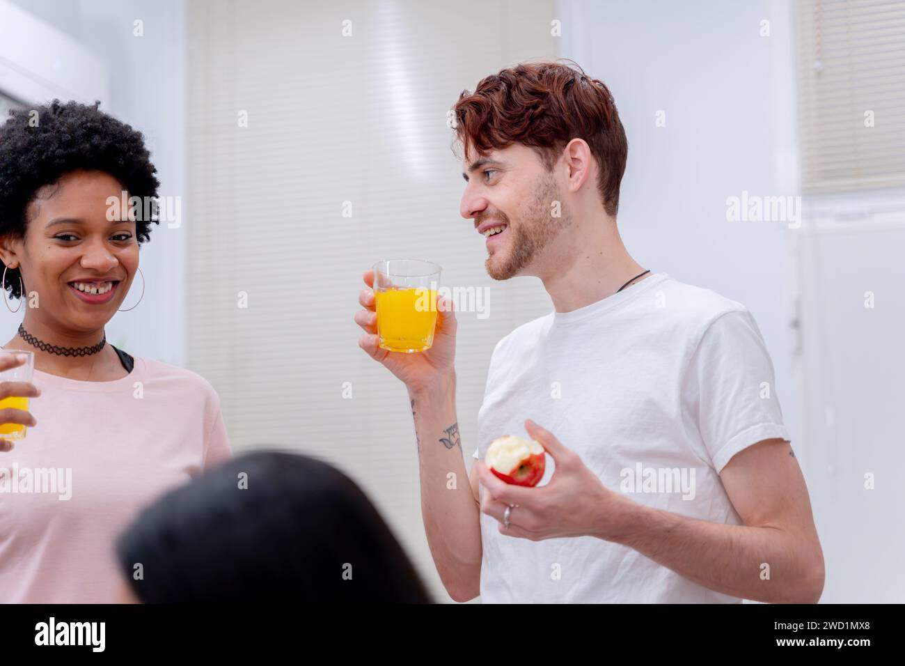 A man and woman make a toast with glasses of orange juice, sharing a ...