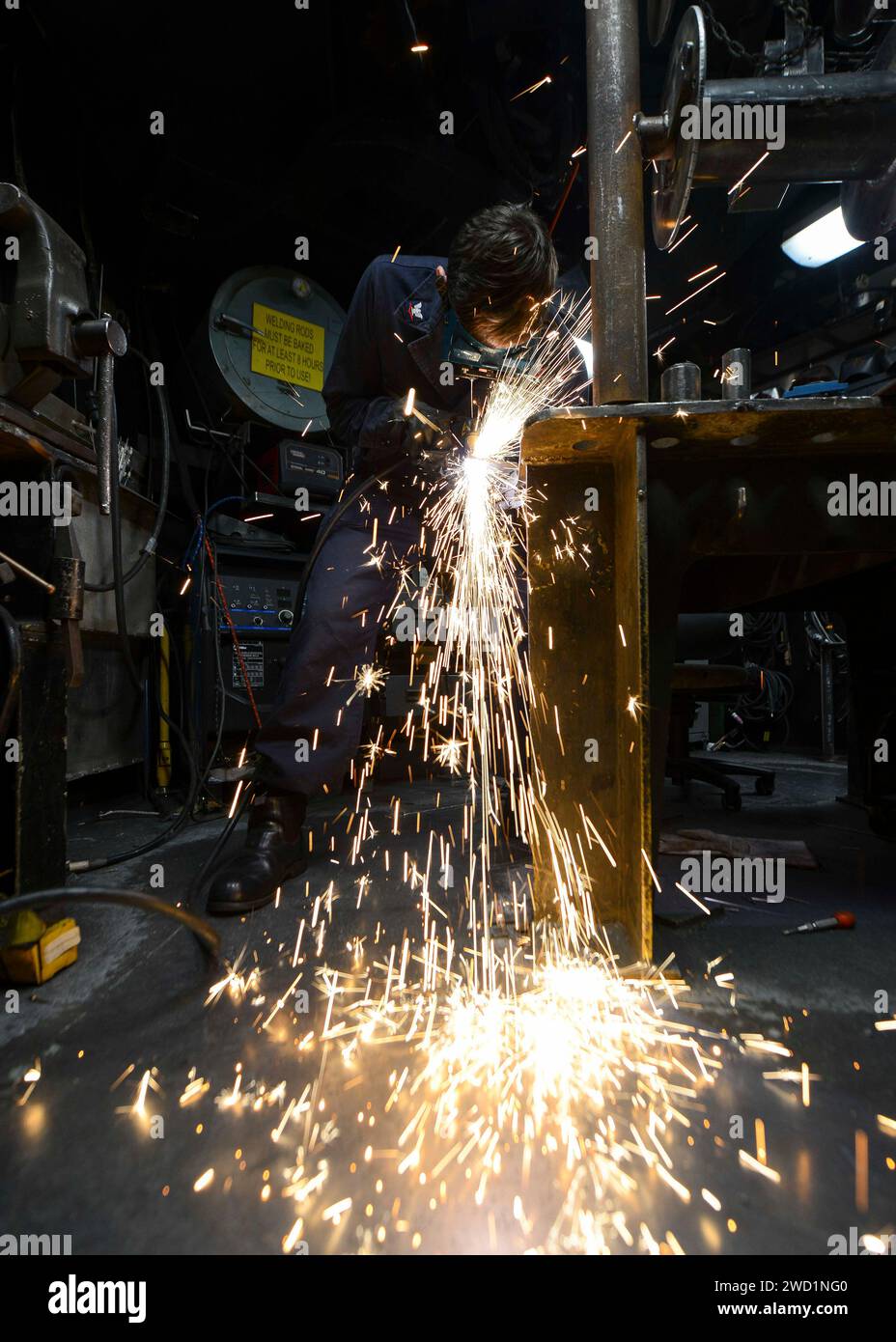 U.S. Navy Hull Technician cuts a piece of steel using a plasma cutter ...