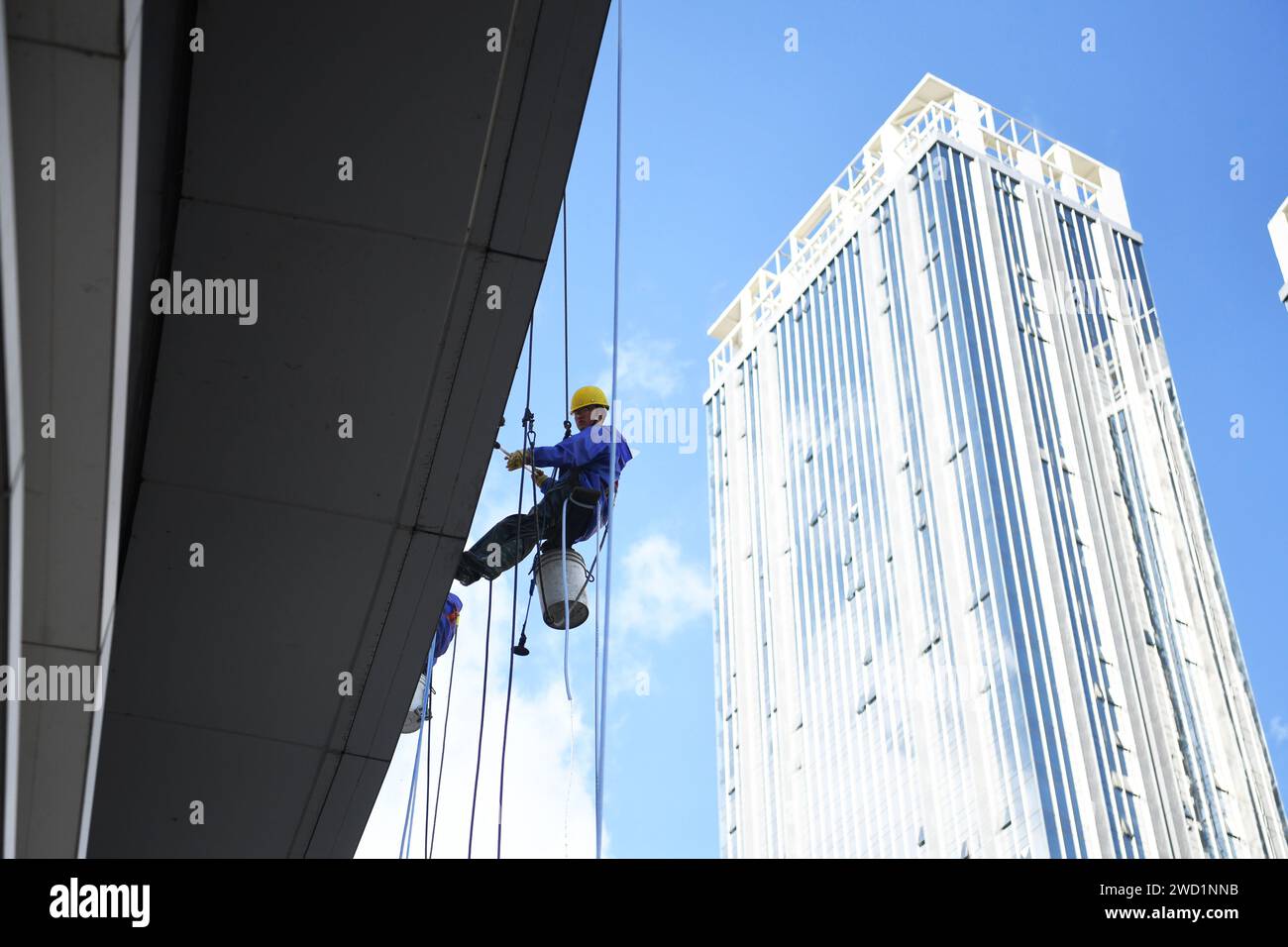 Cleaners perform high-altitude cleaning on the exterior facade of the ...