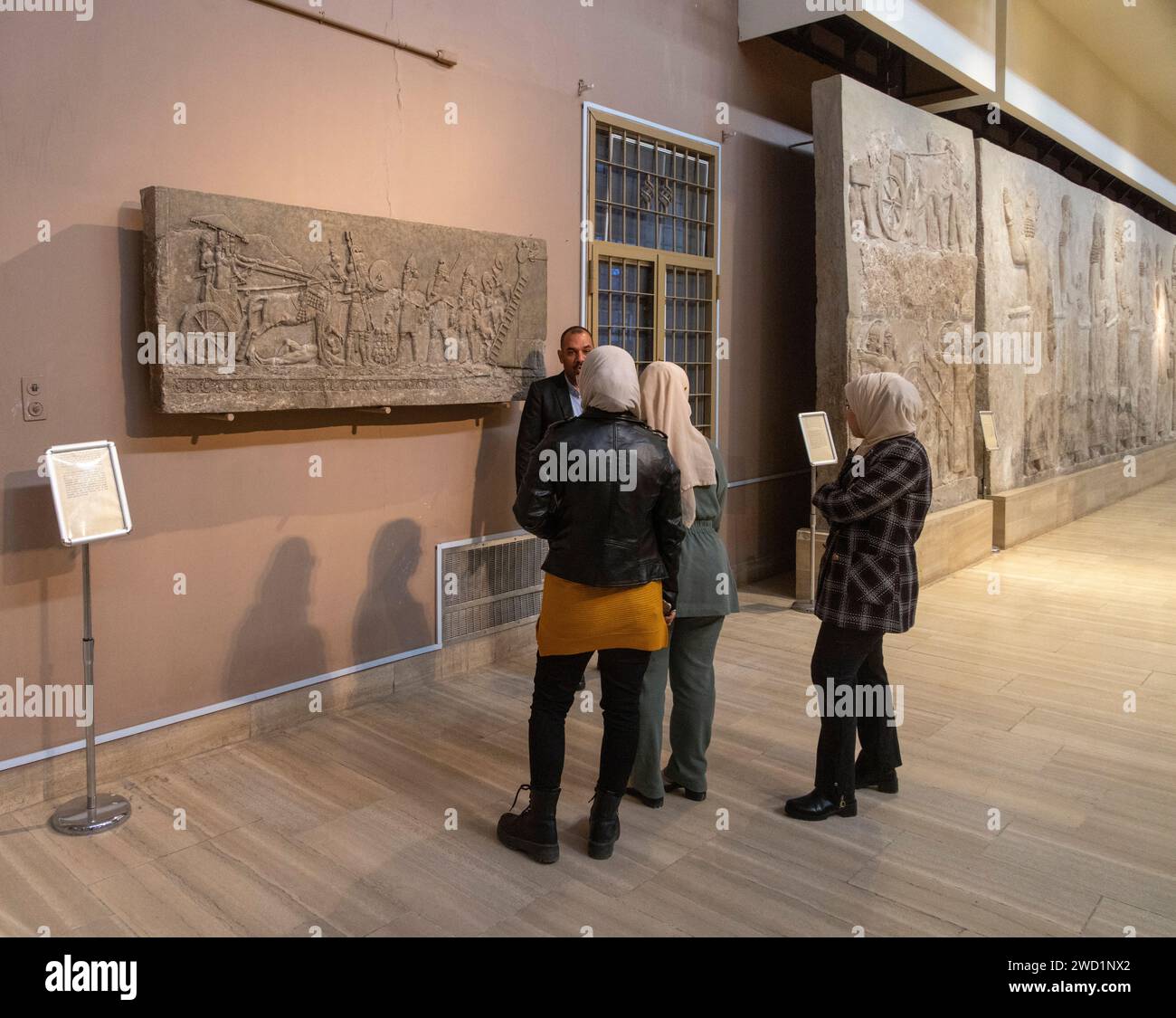 visiters and guide, carved stone reliefs, Assyrian palace of Dur ...