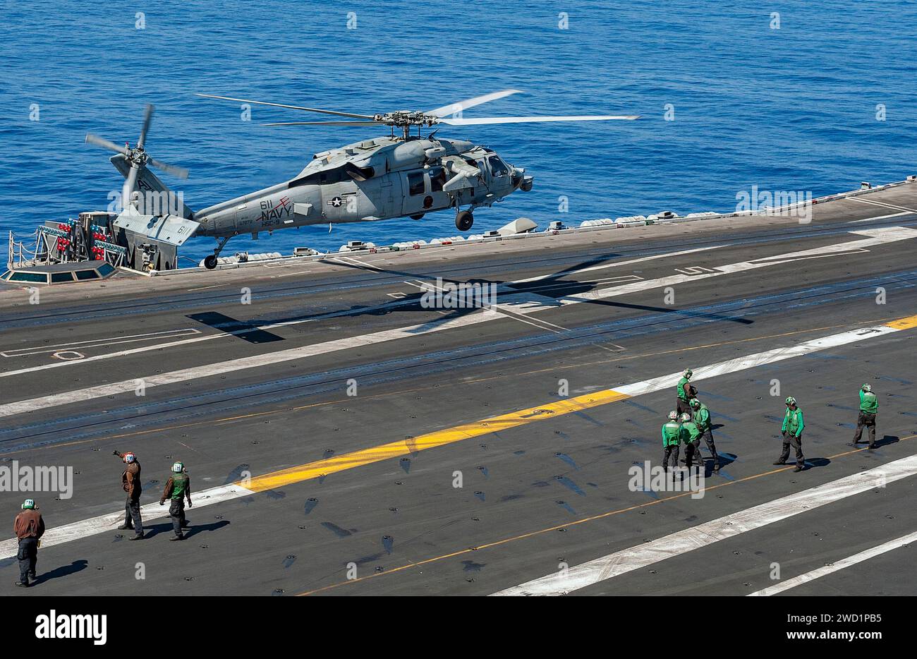 An MH-60S Sea Hawk helicopter takes off from the aircraft carrier USS ...