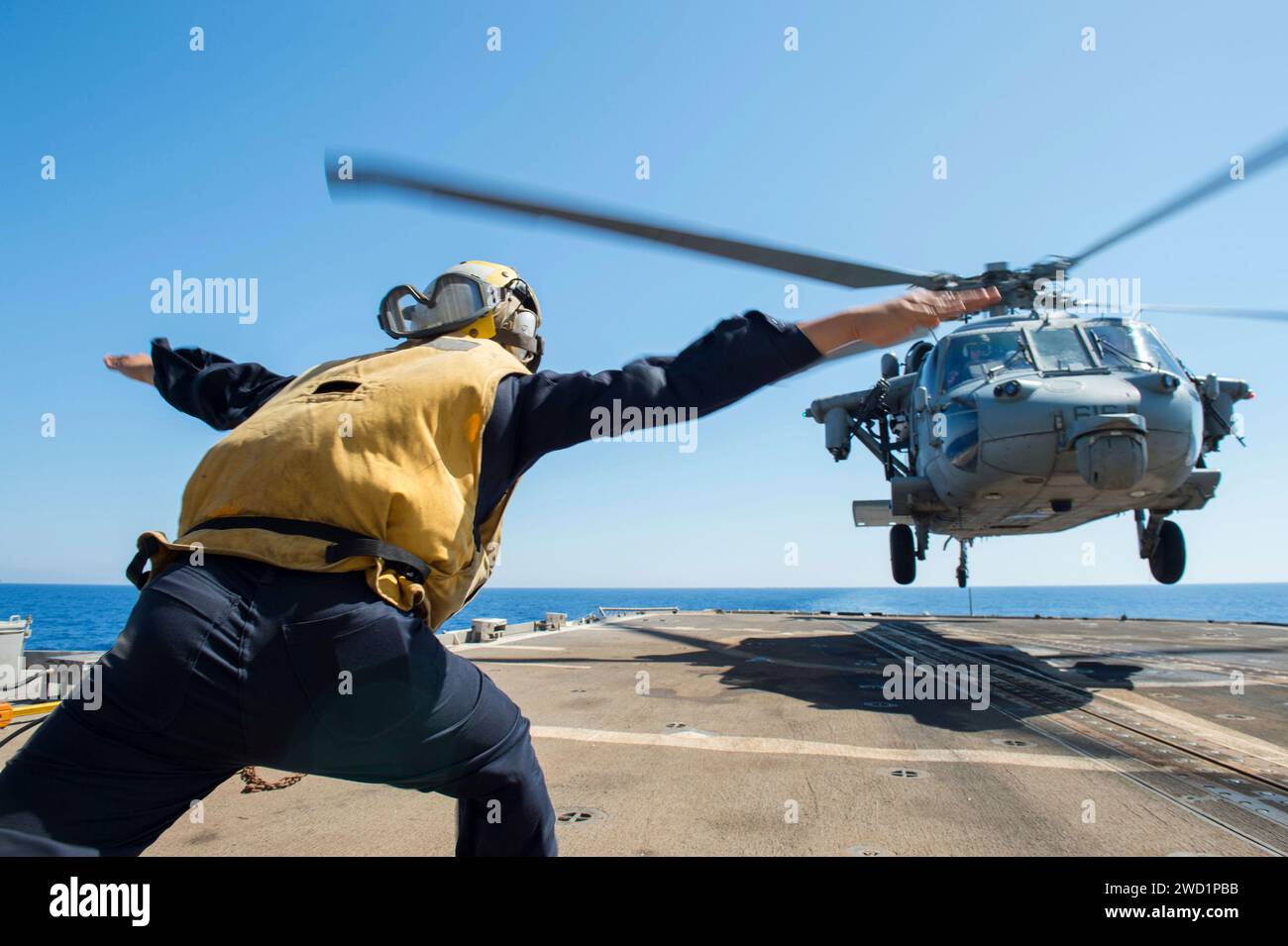 Personnel Specialist guides an MH-60S Sea Hawk helicopter on the flight ...