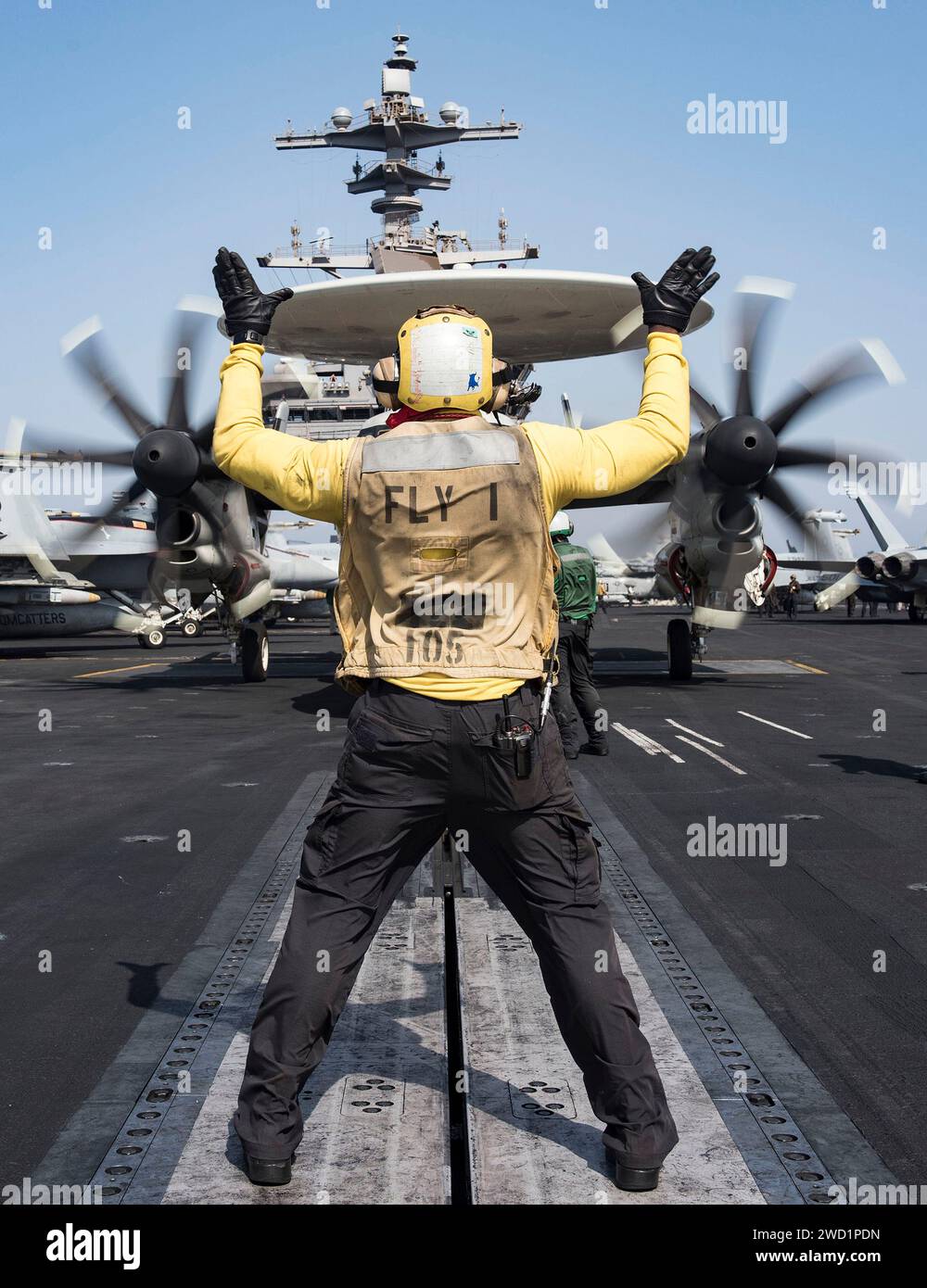 Aviation Boatswain's Mate directs an E-2C Hawkeye aboard USS George H.W ...