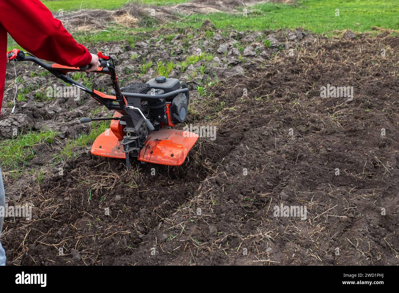 Work on a home farm in the spring. Plowing the field with a cultivator ...