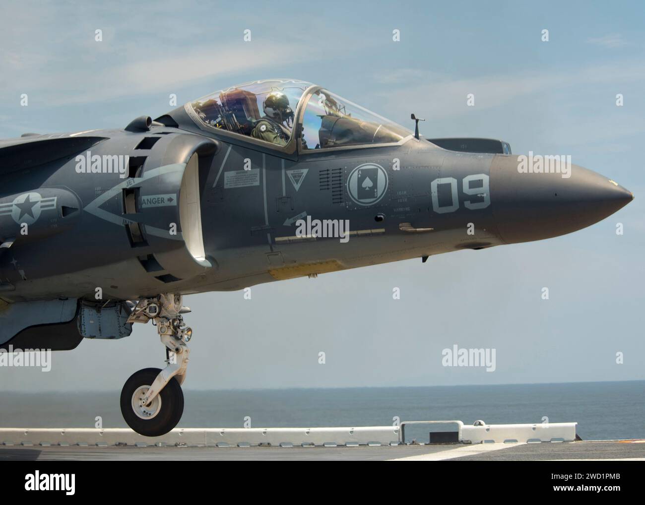 An AV-8B Harrier lands on the flight deck of the amphibious assault ...