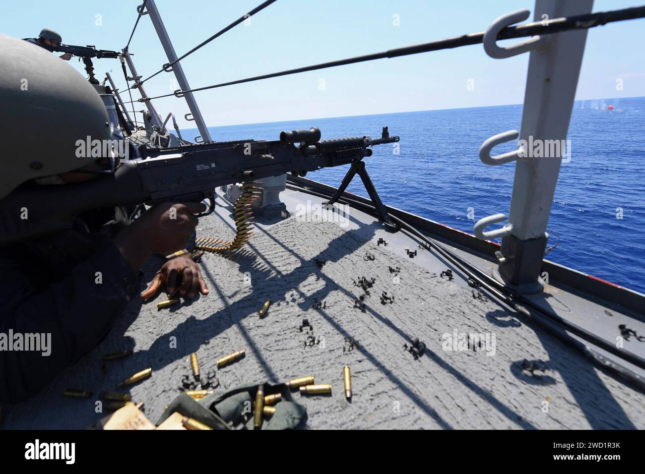Sonar Technician fires an M250B machine gun aboard USS Oscar Austin ...