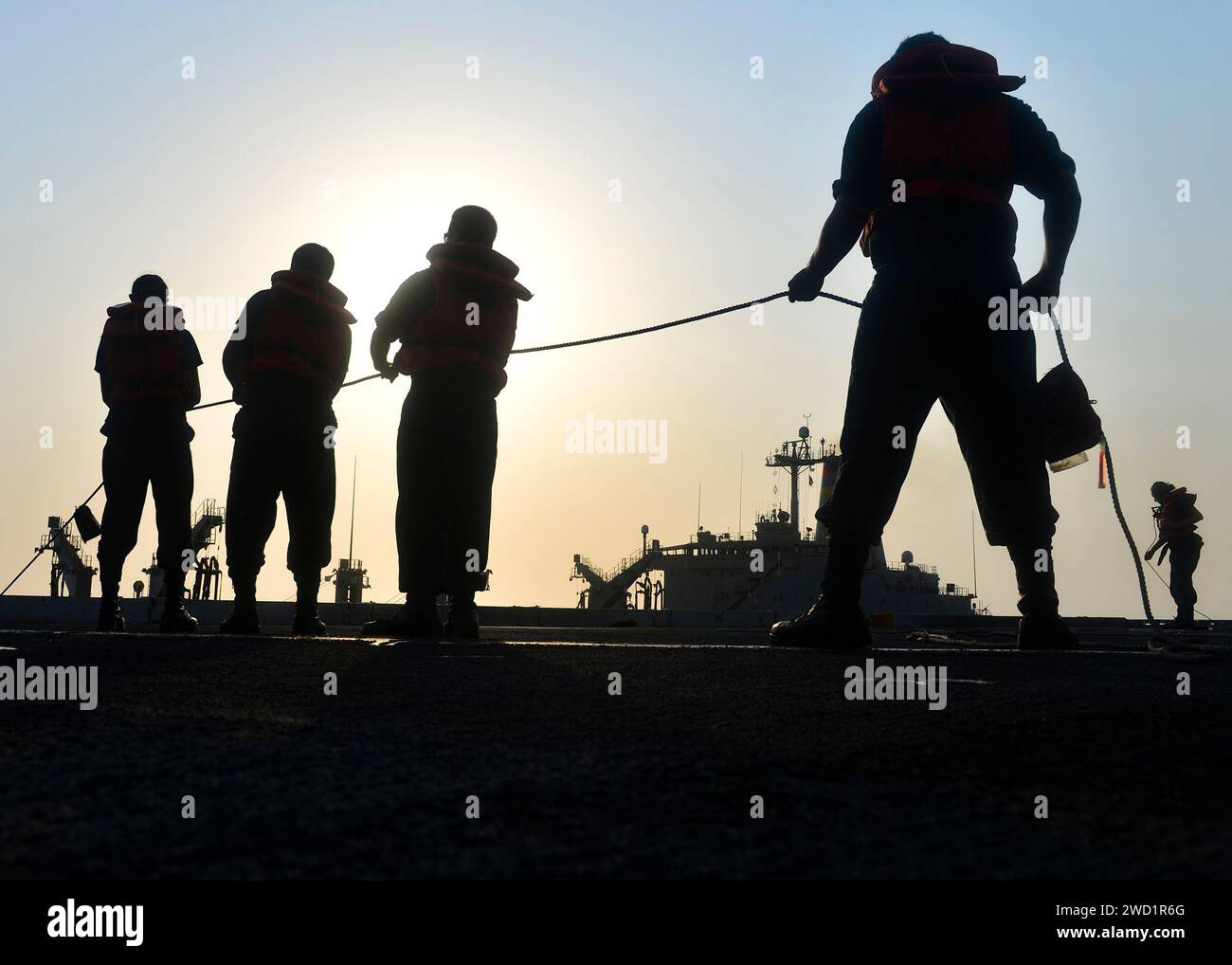 Sailors hold a line aboard the aircraft carrier USS Nimitz during a ...