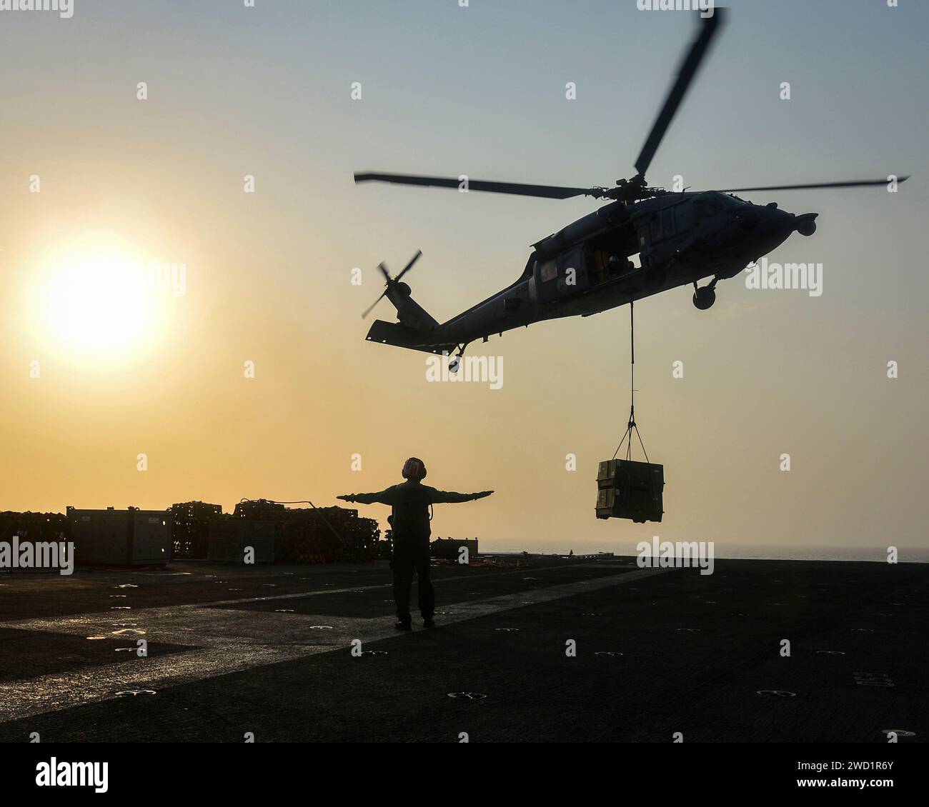 U.S. Navy Airman directs an MH-60S Sea Hawk helicopter aboard USS ...