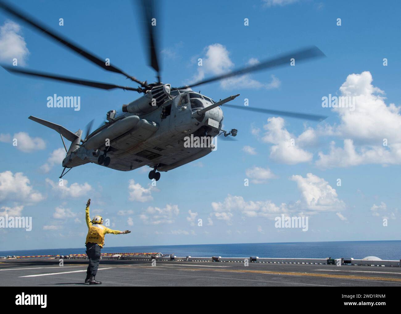 Airman signals the pilot of a CH-53E Super Stallion as the helicopter ...