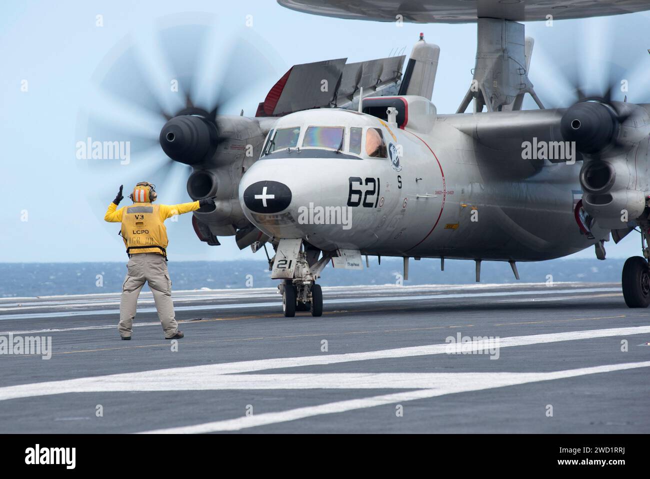 Aviation Boatswain's Mate directs an E-2C Hawkeye on the flight deck of ...