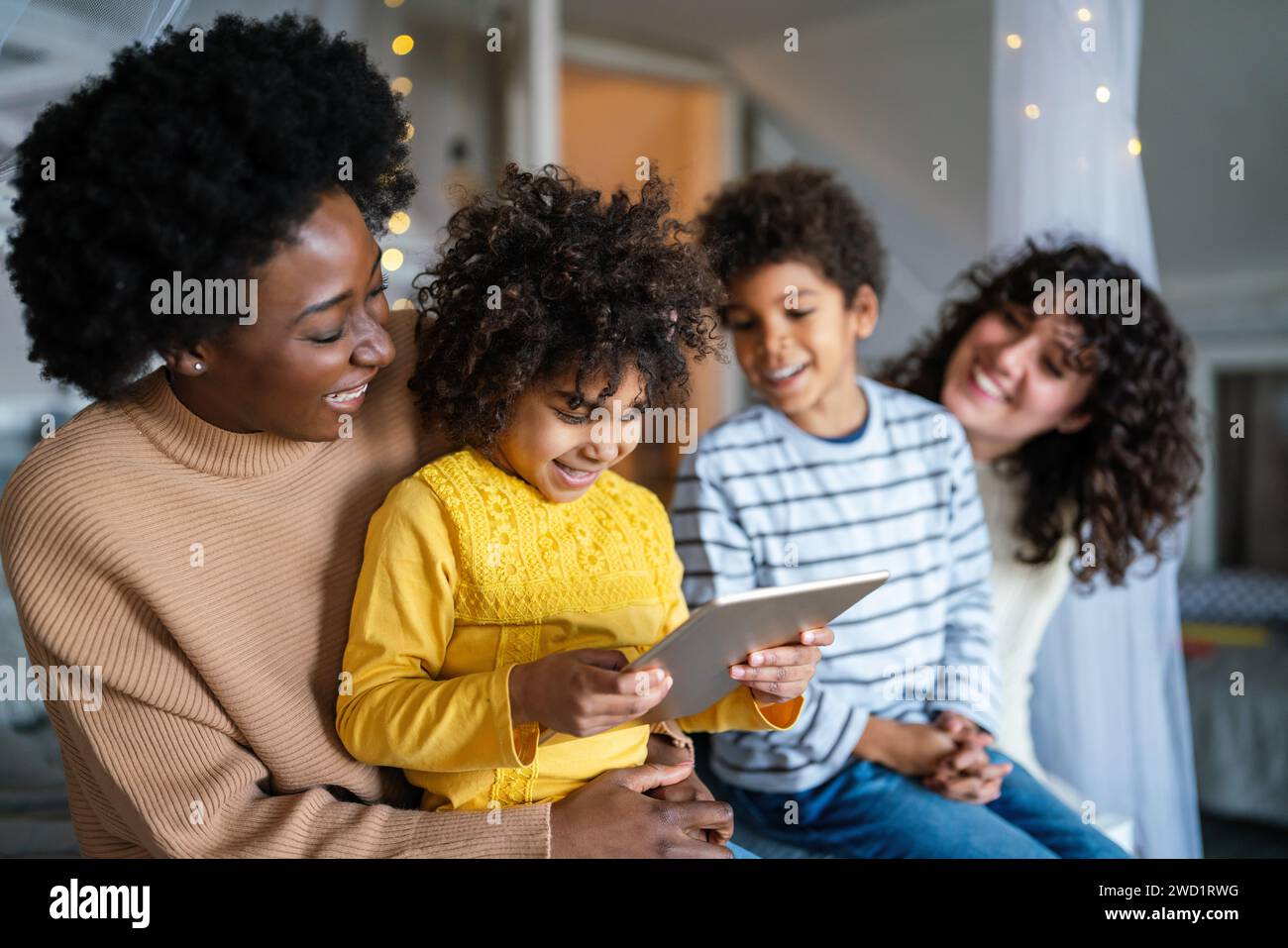 Happy multiethnic family having fun with digital device at home. Family ...