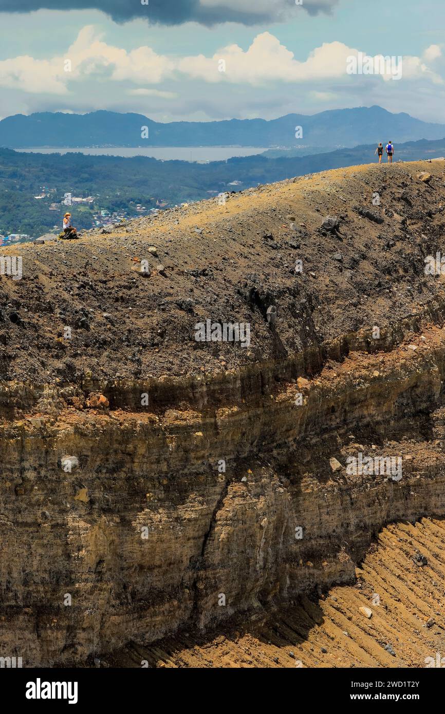 Hikers on the rim of the active Tompaluan crater below Mount Lokon ...