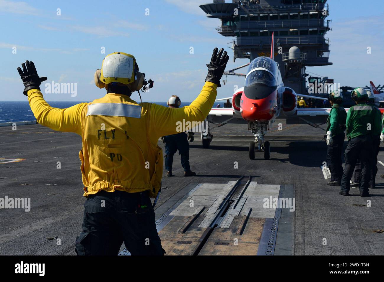 Aviation Boatswain's Mate directs a T-45C Goshawk training aircraft to ...