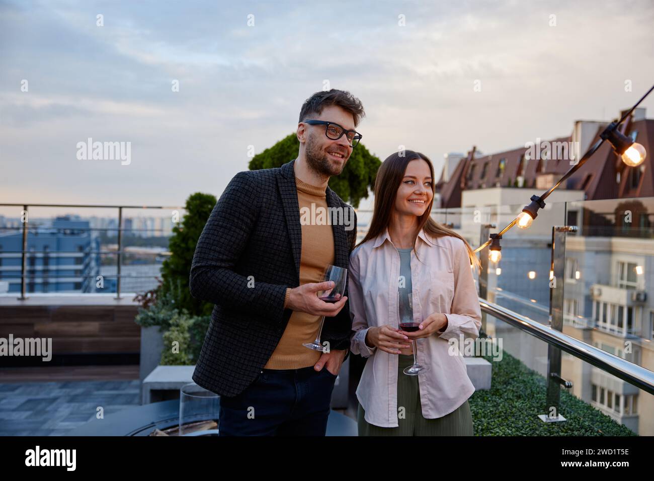 Romantic couple drinking wine having date on roof top Stock Photo - Alamy