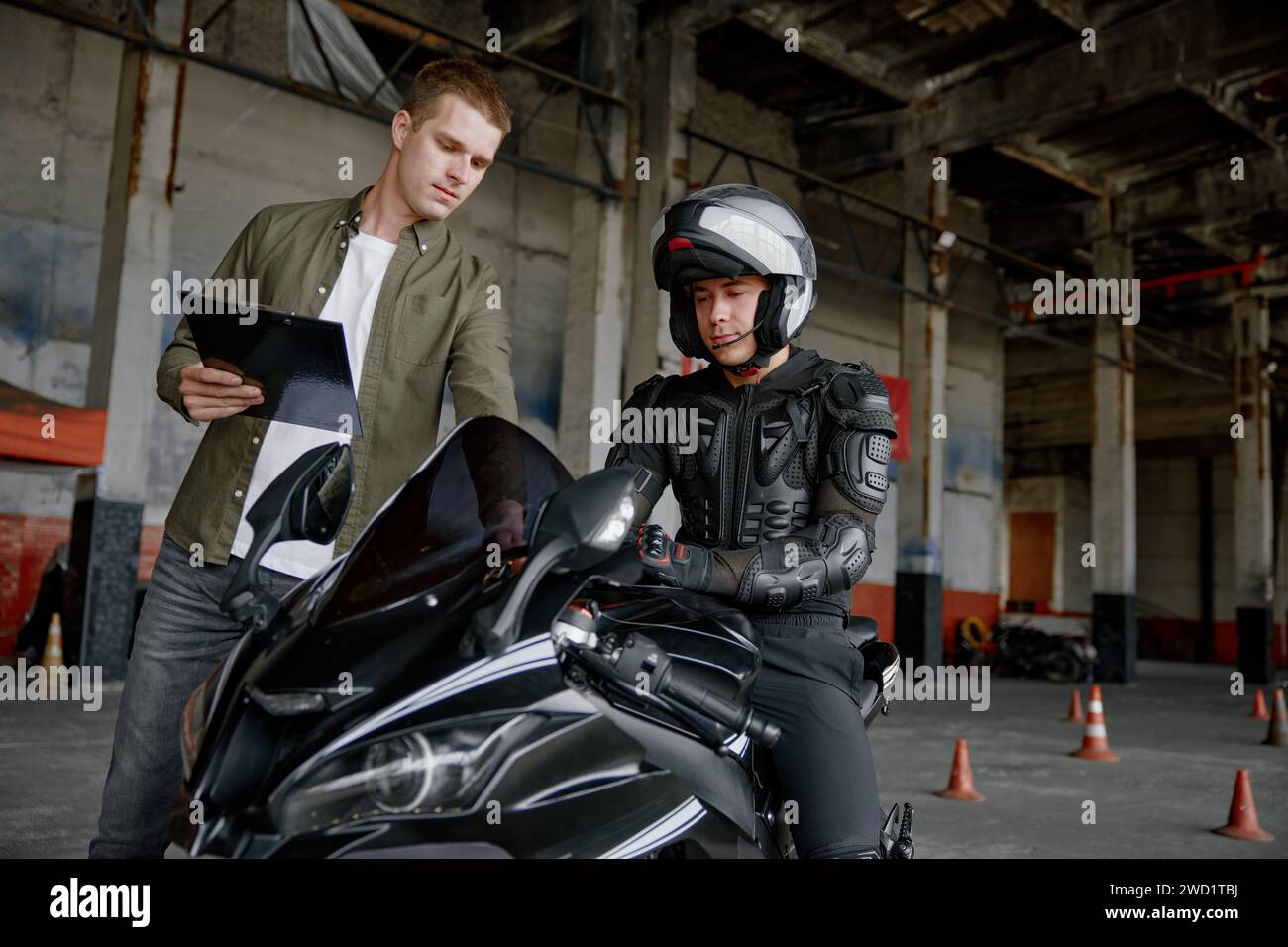 Male instructor teaching young biker at personal lesson at motorcycle ...