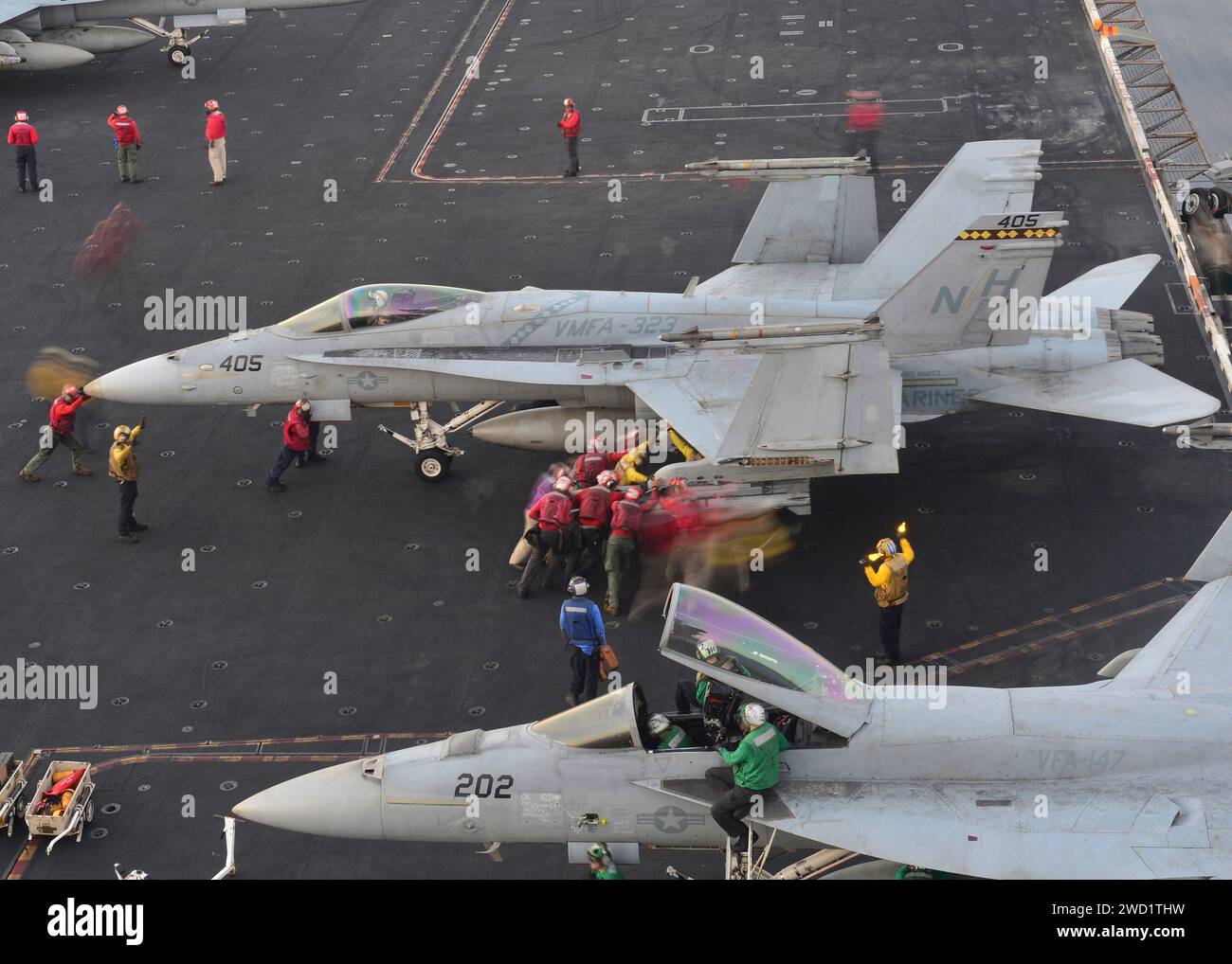U.S. Sailors and Marines perform an aircraft push back aboard the ...