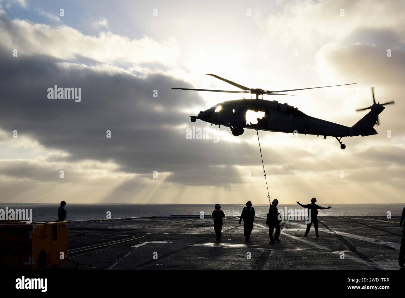 An MH-60S Sea Hawk helicopter transports cargo during a replenishment ...