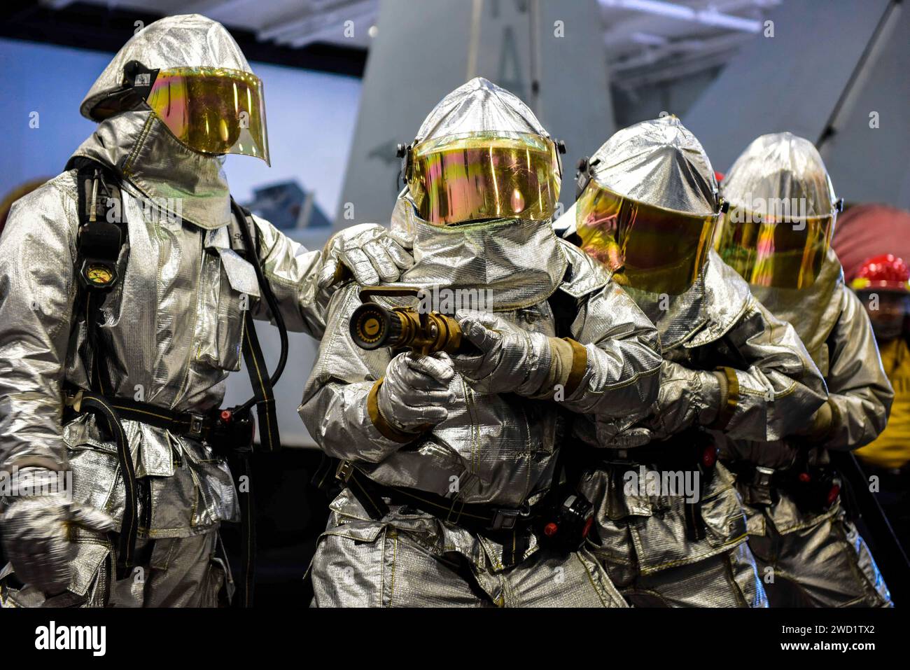 Sailors participate in a general quarters drill in the hangar bay ...