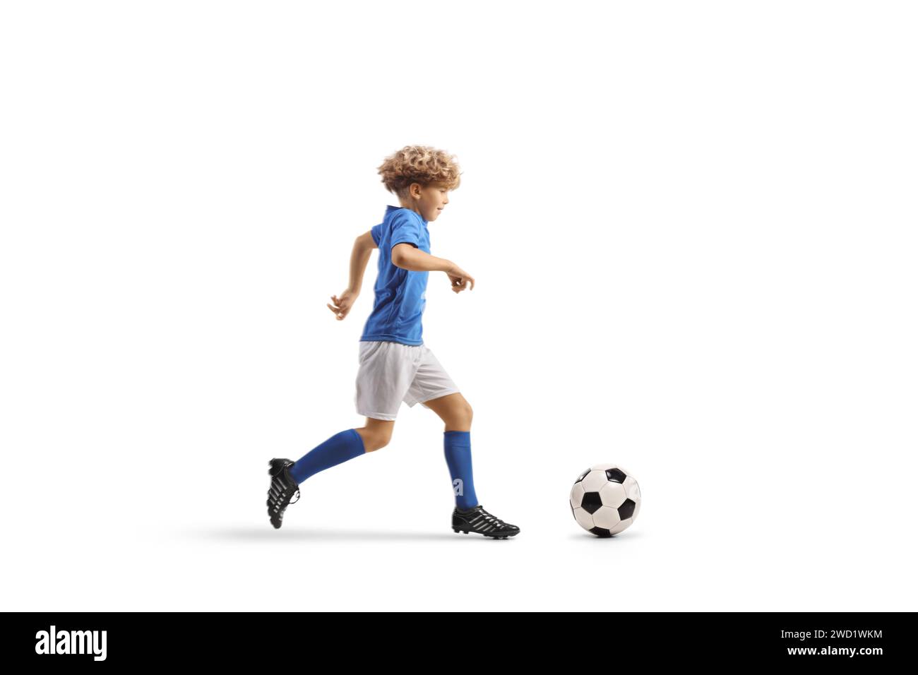 Full length profile shot of a boy in a football kit running and leading ...