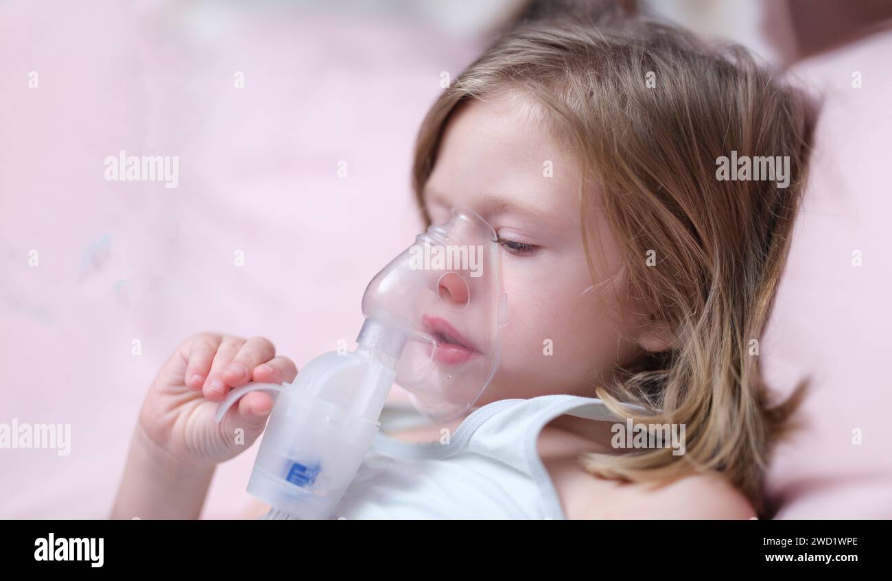 Child with inhaler mask breathing problems with asthma Stock Photo - Alamy