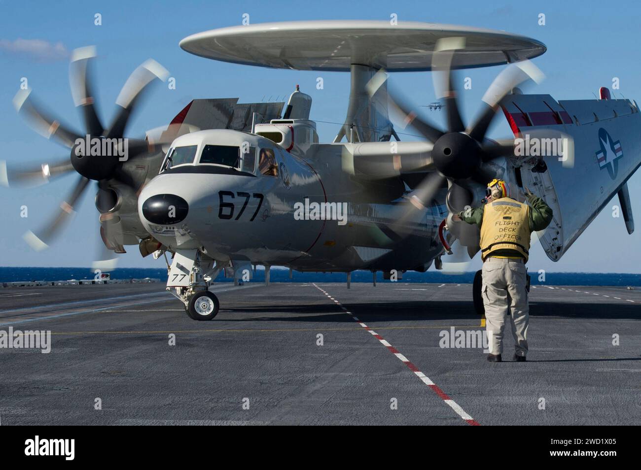 An E-2C Hawkeye is directed on the flight deck aboard USS Harry S ...