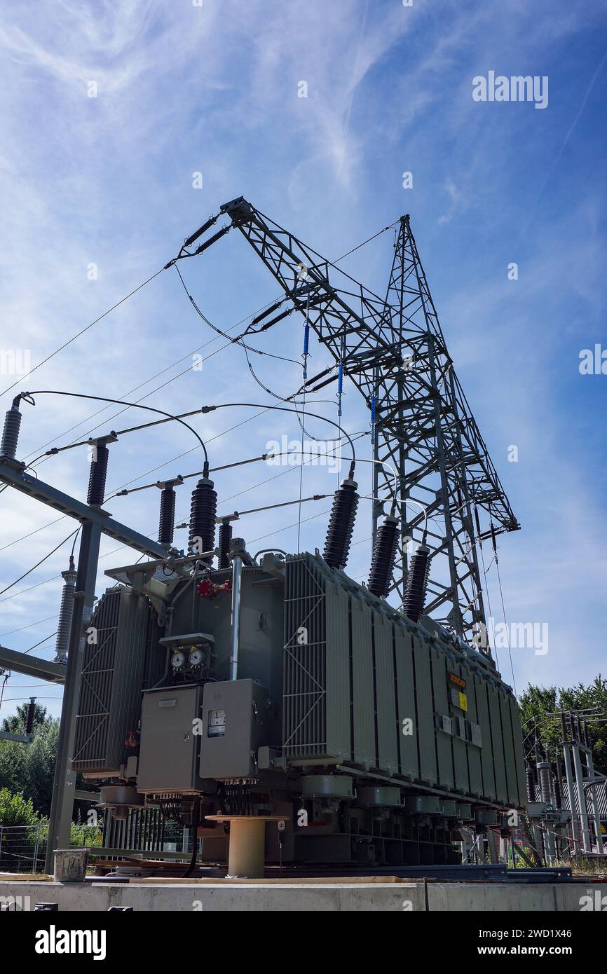 A transformer in front of a high-voltage tower at a substation in Hesse ...