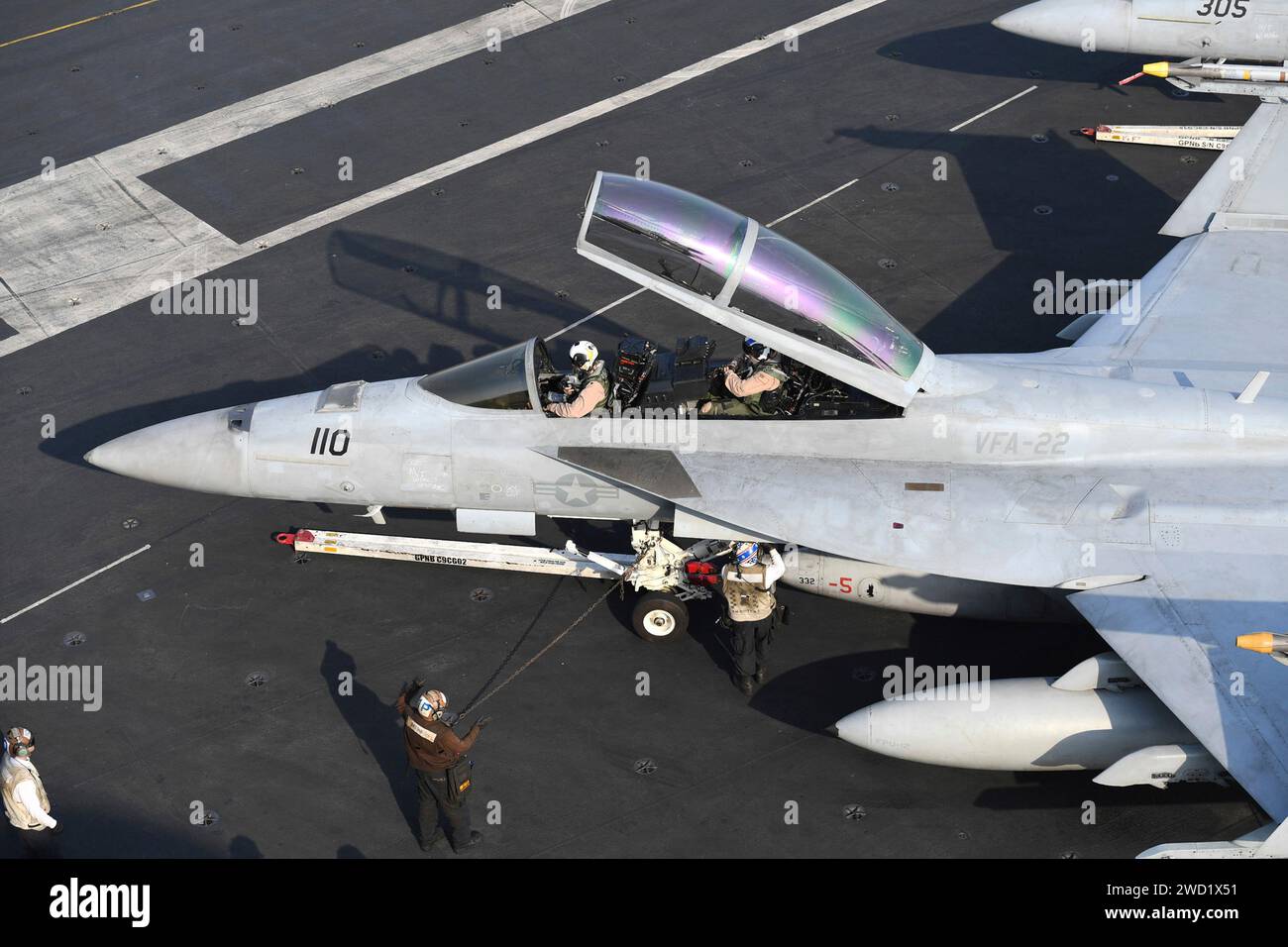 Sailors guide an F/A-18F Super Hornet during a preflight inspection on the flight deck of USS ...