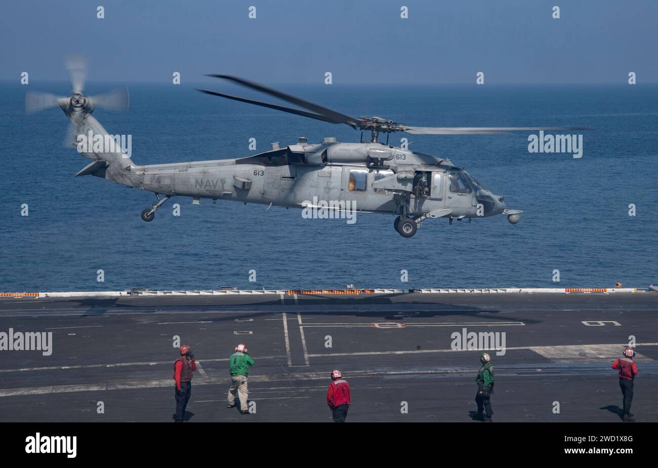 An MH-60S Sea Hawk helicopter takes off on the flight deck aboard the ...