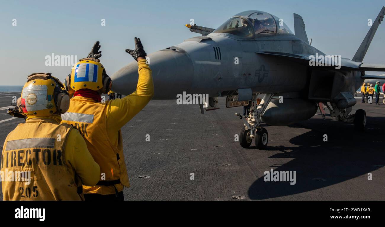 A Sailor directs an F/A-18F Super Hornet across the flight deck of USS Nimitz Stock Photo - Alamy