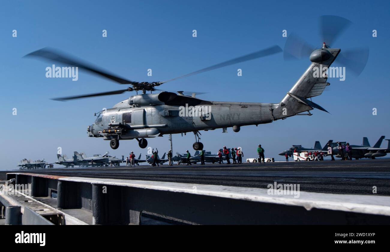 An MH-60R Sea Hawk helicopter lifts off the flight deck of the aircraft ...
