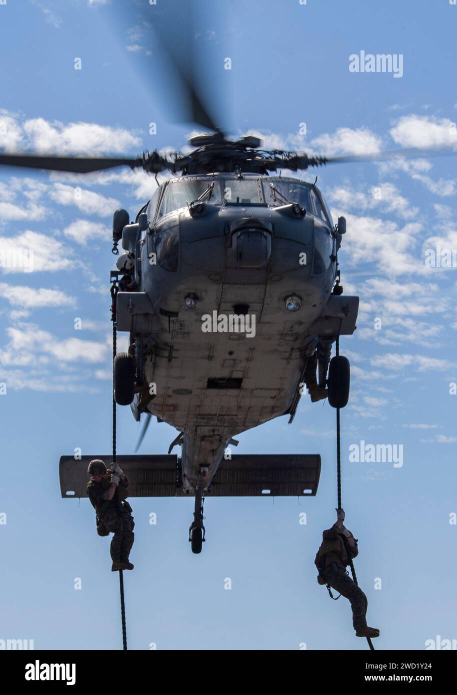 U.S. Marines fast-rope from a U.S. Navy MH-60S Sea Hawk helicopter ...
