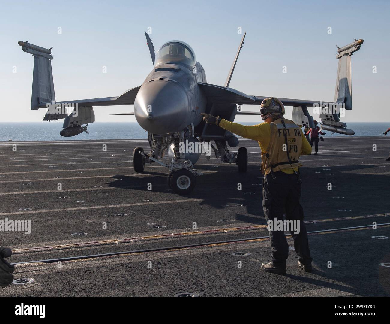A Sailor directs an F/A-18E Super Hornet on the flight deck of USS Nimitz Stock Photo - Alamy