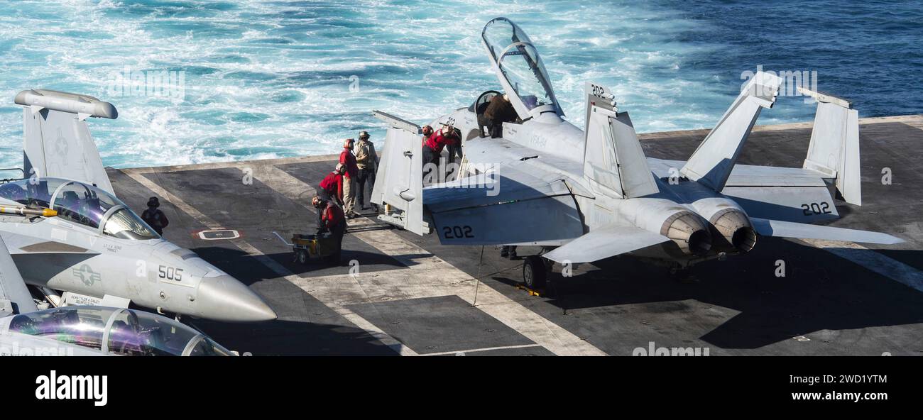 Sailors perform maintenance on an F/A-18F Super Hornet on the flight deck of USS Nimitz Stock ...