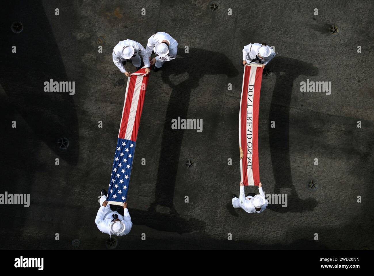 U.S. Sailors fold the national ensign and the First Navy Jack after ...