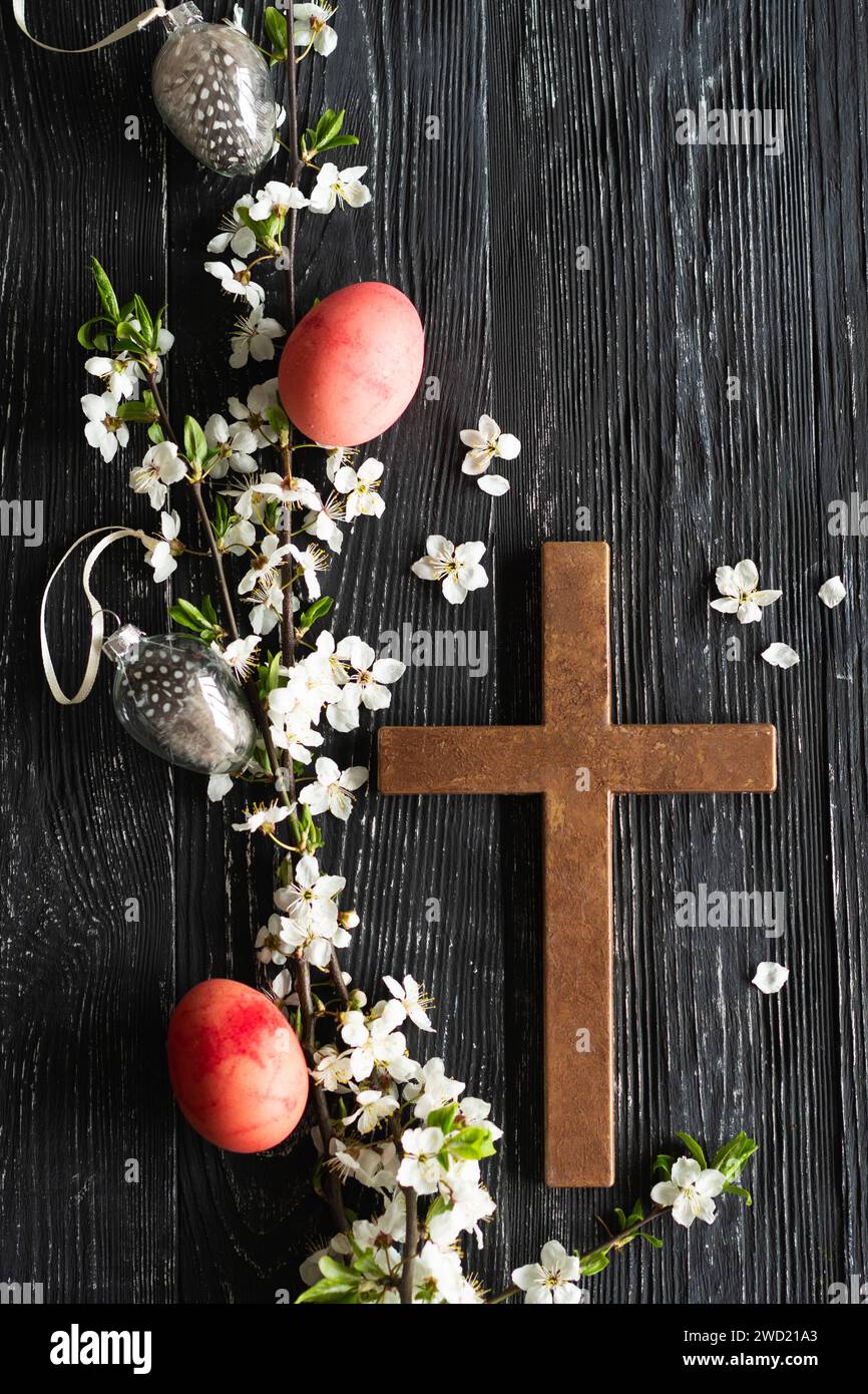 Spring cherry blossoms and Easter eggs and cross on old wooden ...