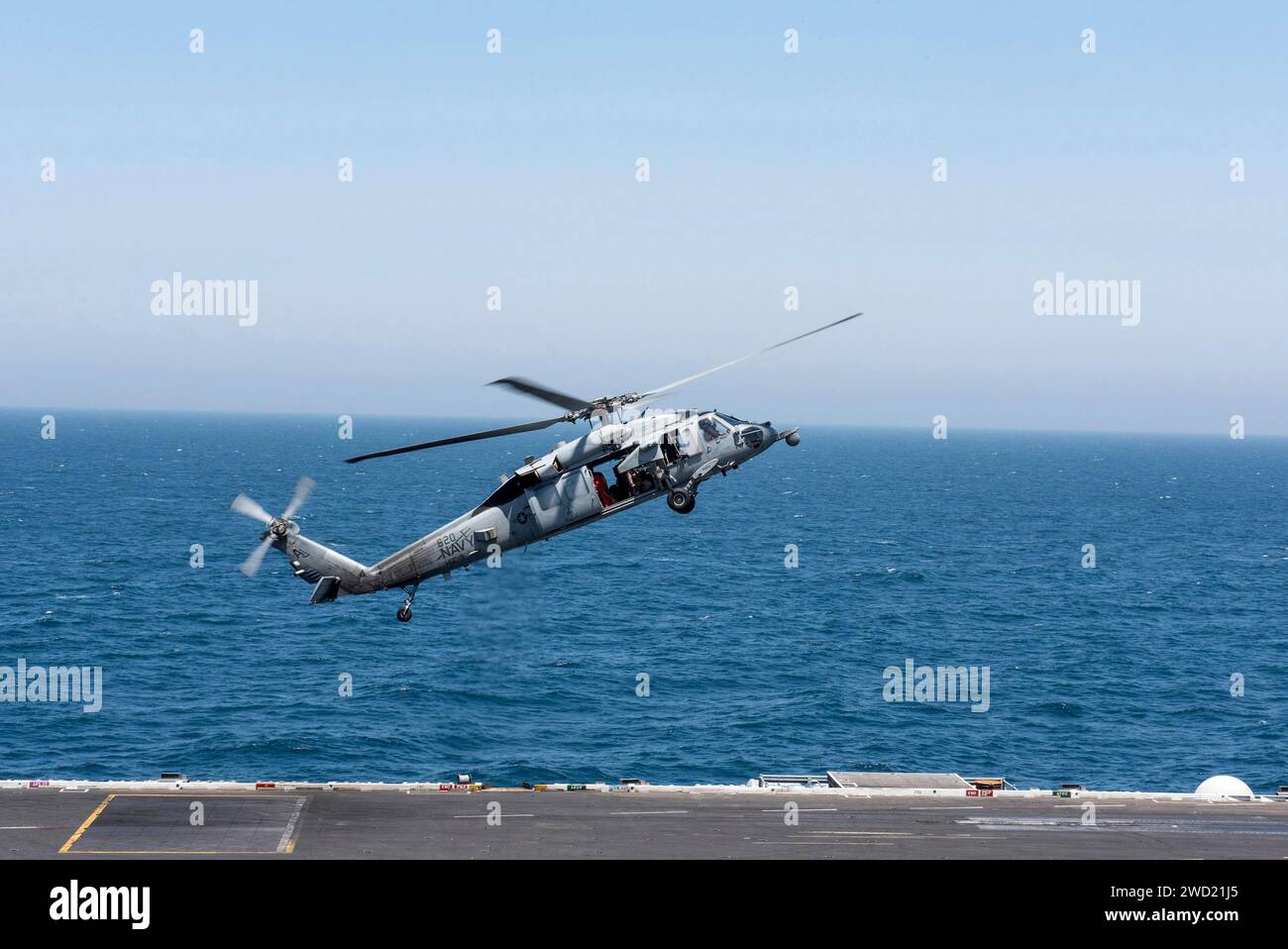 An MH-60S Sea Hawk helicopter prepares to land on the flight deck of ...