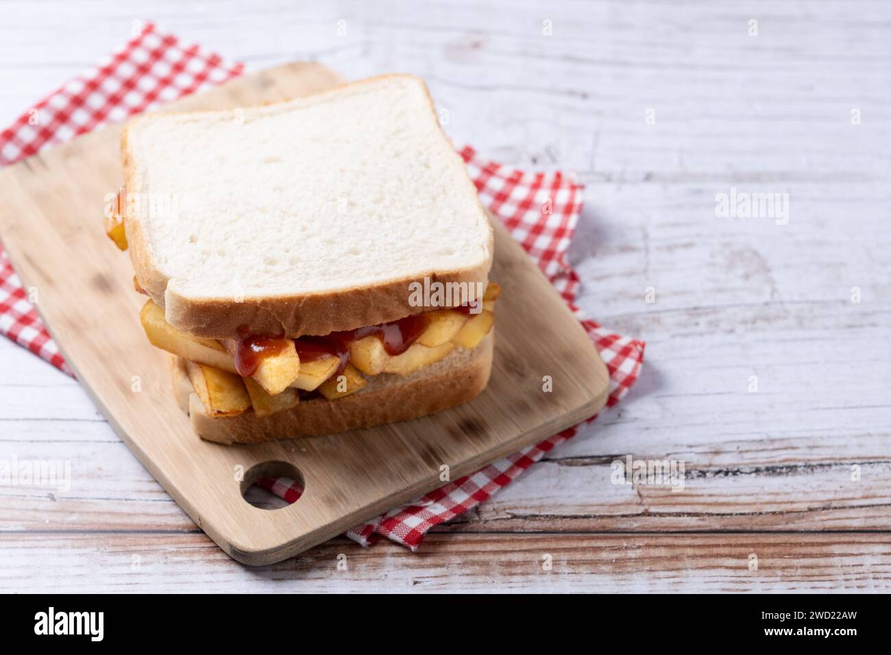 Traditional British chip butty (french fry sandwich) on wooden table ...