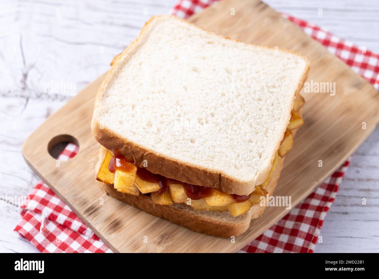 Traditional British chip butty (french fry sandwich) on wooden table ...