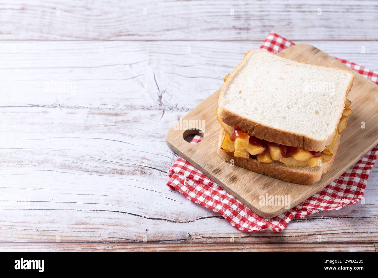 Traditional British chip butty (french fry sandwich) on wooden table ...