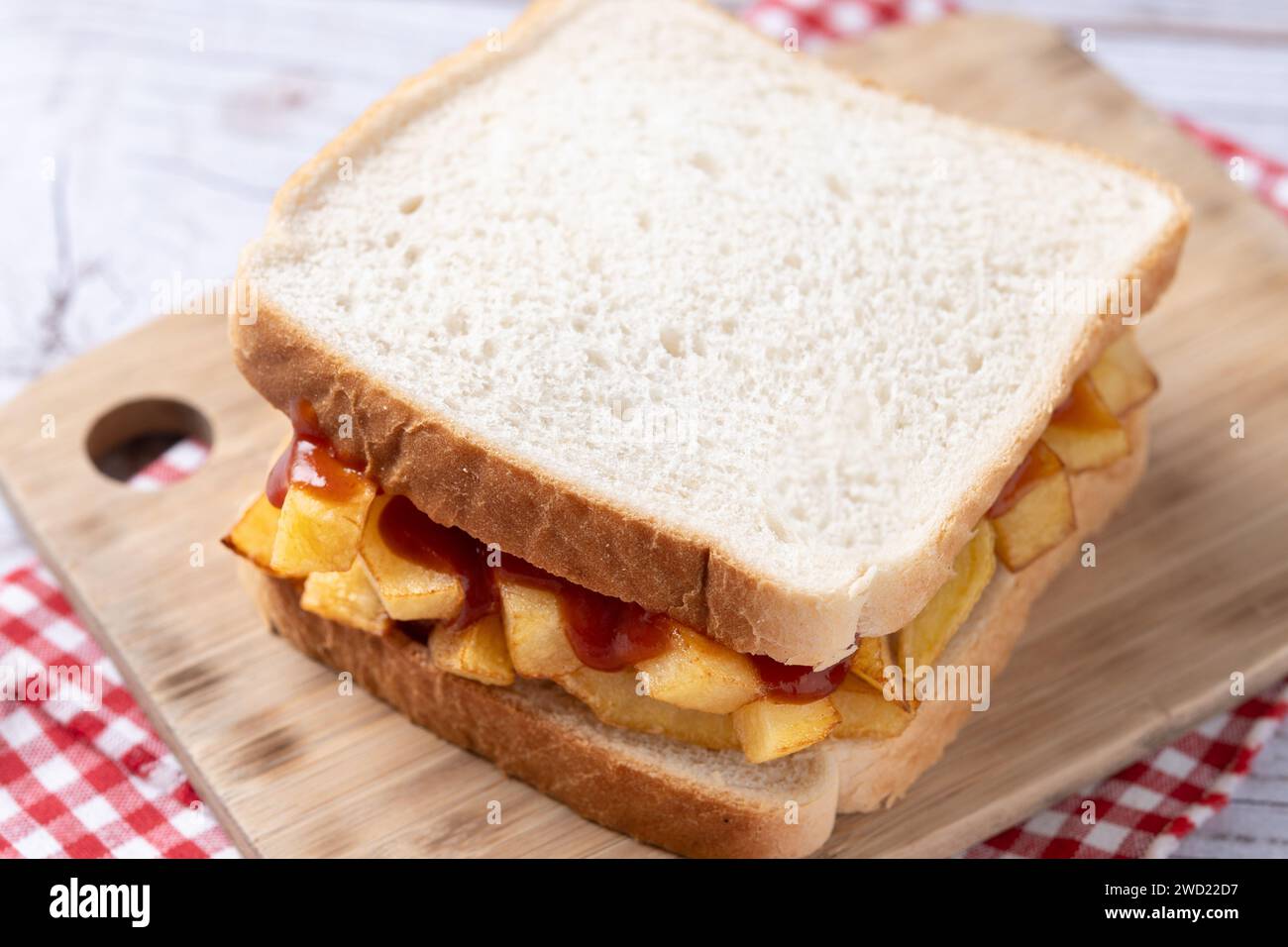 Traditional British chip butty (french fry sandwich) on wooden table ...