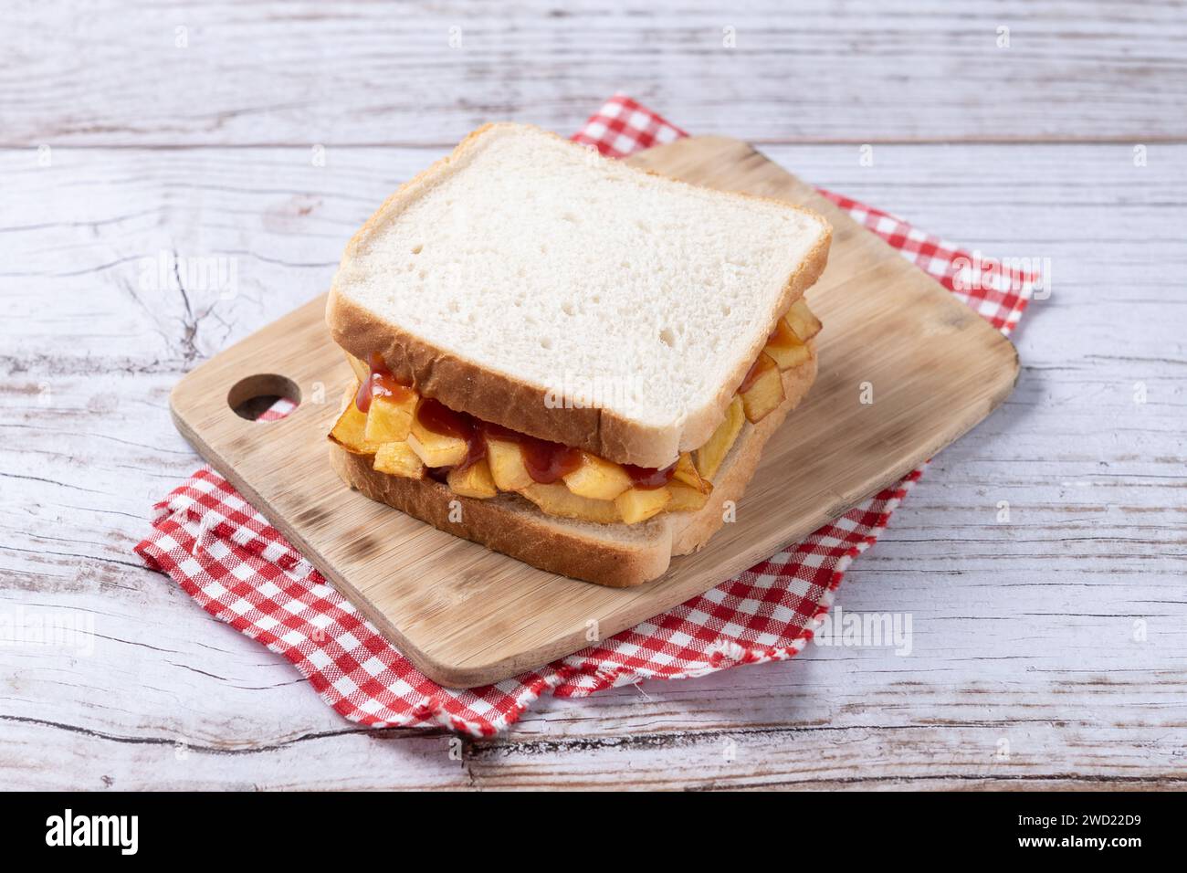 Traditional British chip butty (french fry sandwich) on wooden table ...