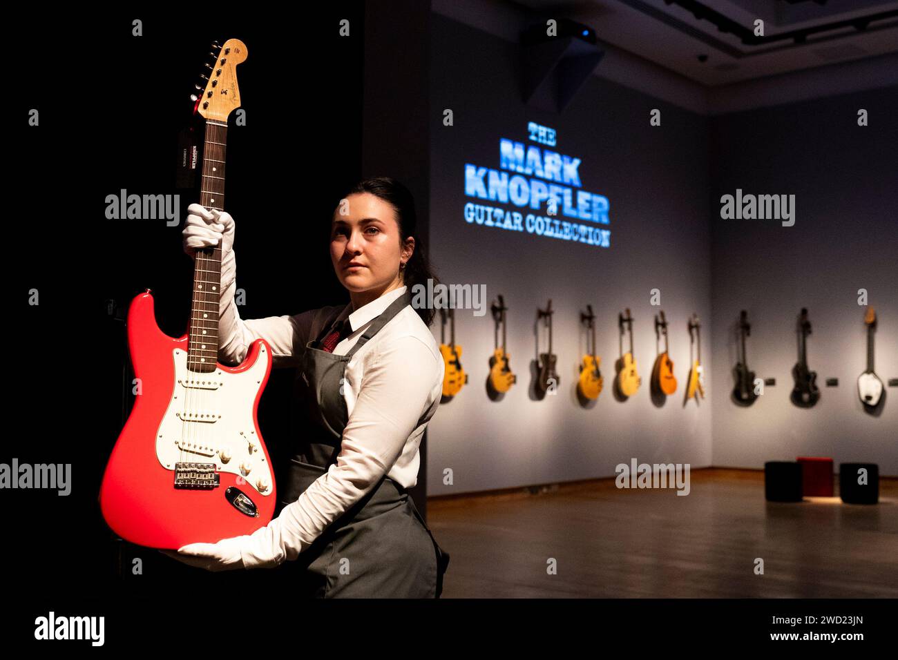 A Christie's art handler holds up Mark Knopfler's Red Schecter ...
