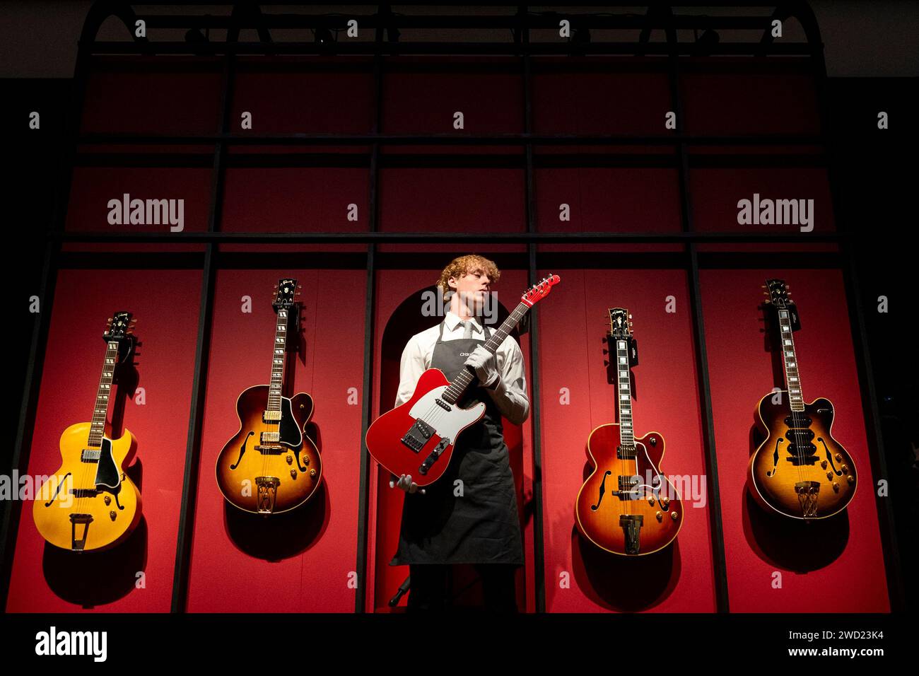 A Christie's art handler holds up Mark Knopfler's Red Schecter ...