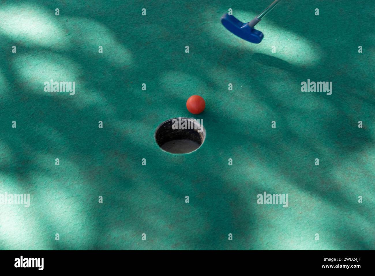 Somebody is playing minigolf with a red ball. Mini golf recreation ...