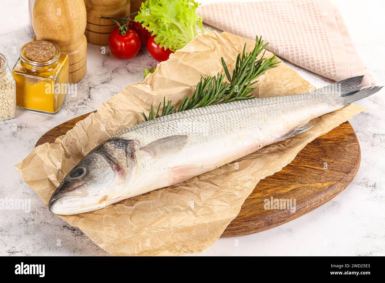 Raw seabass fish for cooking served rosemary Stock Photo - Alamy