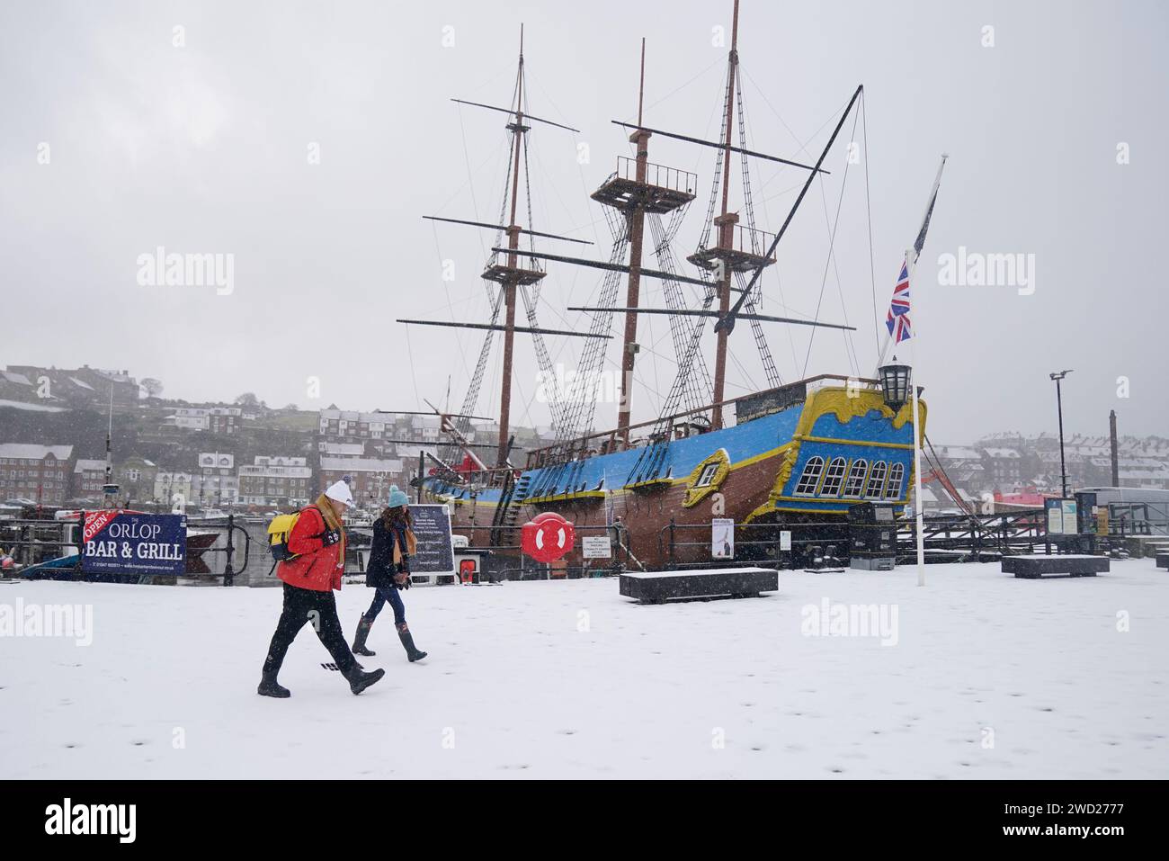 People walk through snow in Whitby. Hundreds of schools are shut, some ...
