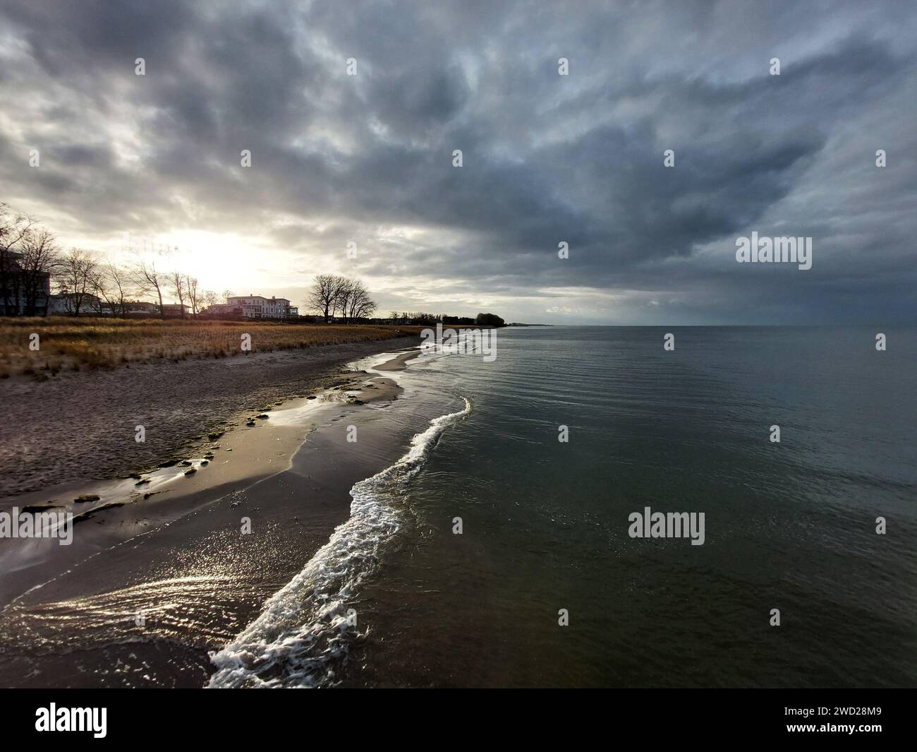 The sun is breaking through clouds at the beach of the Baltic Sea in ...