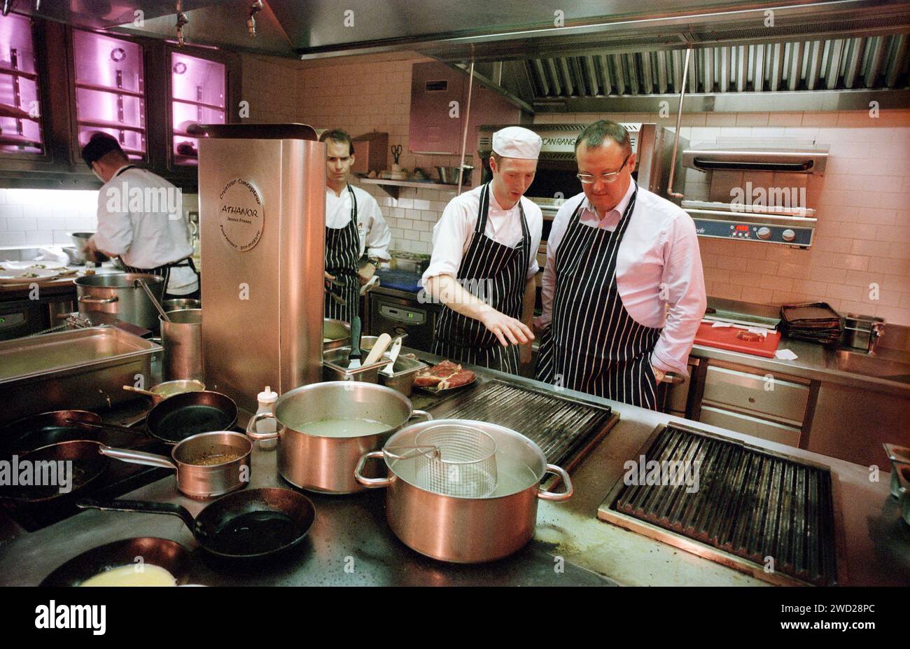 Chefs preparing steaks in an open to view kitchen for the customers at ...