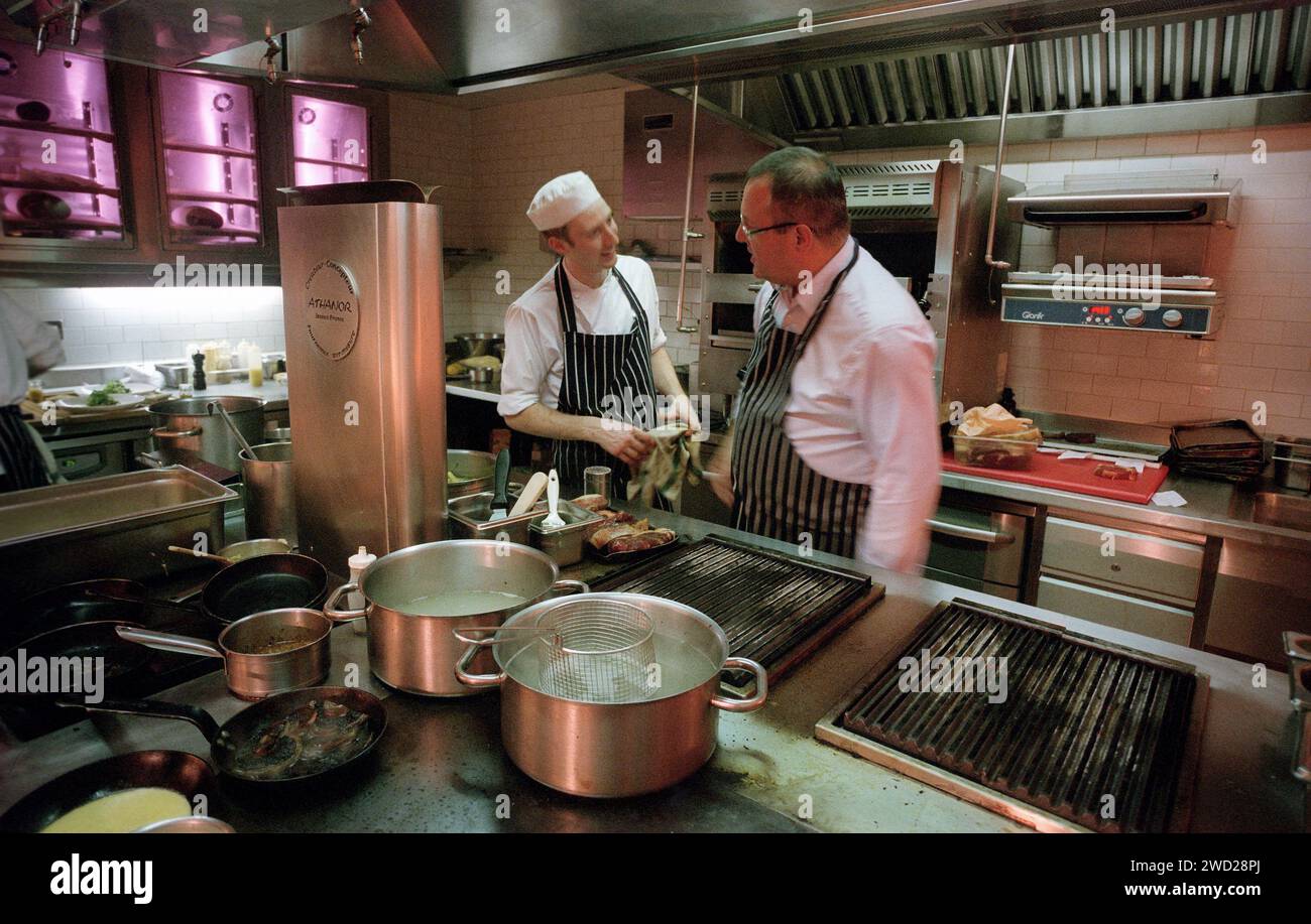 Chefs preparing steaks in an open to view kitchen for the customers at ...